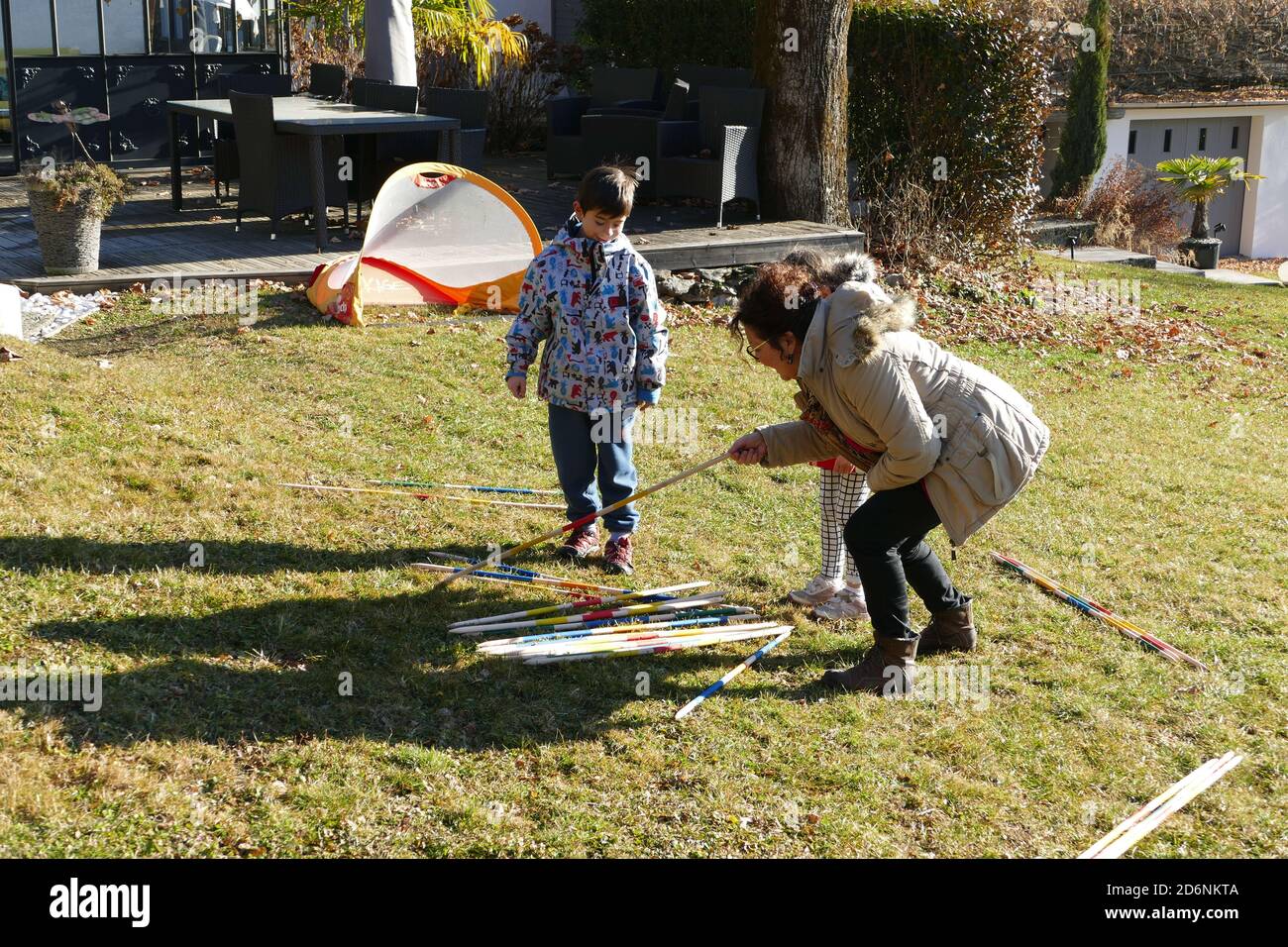 Grandmother playing giant Mikado with her grandchildren Stock Photo - Alamy