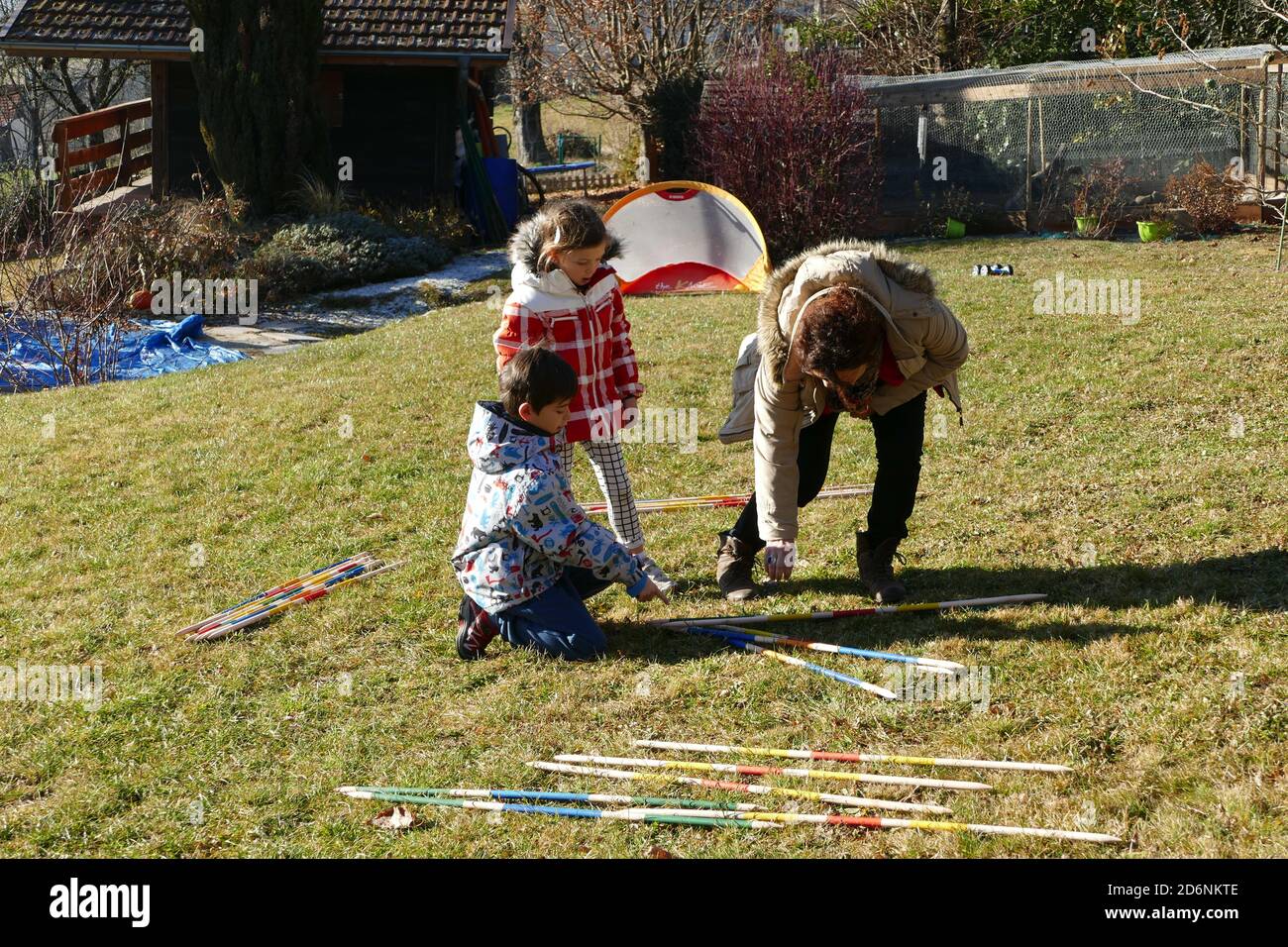 Grandmother playing giant Mikado with her grandchildren Stock Photo - Alamy