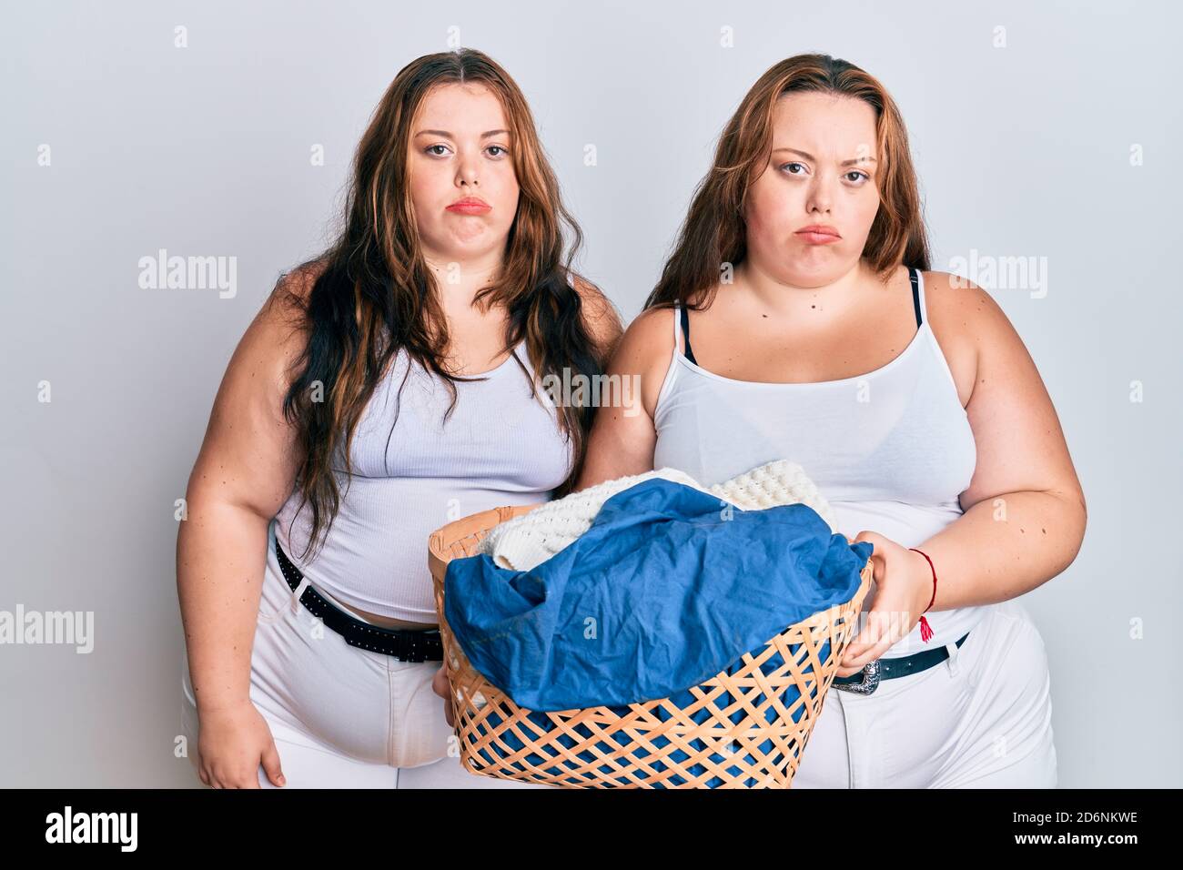 Plus size caucasian sisters woman holding laundry basket depressed and ...