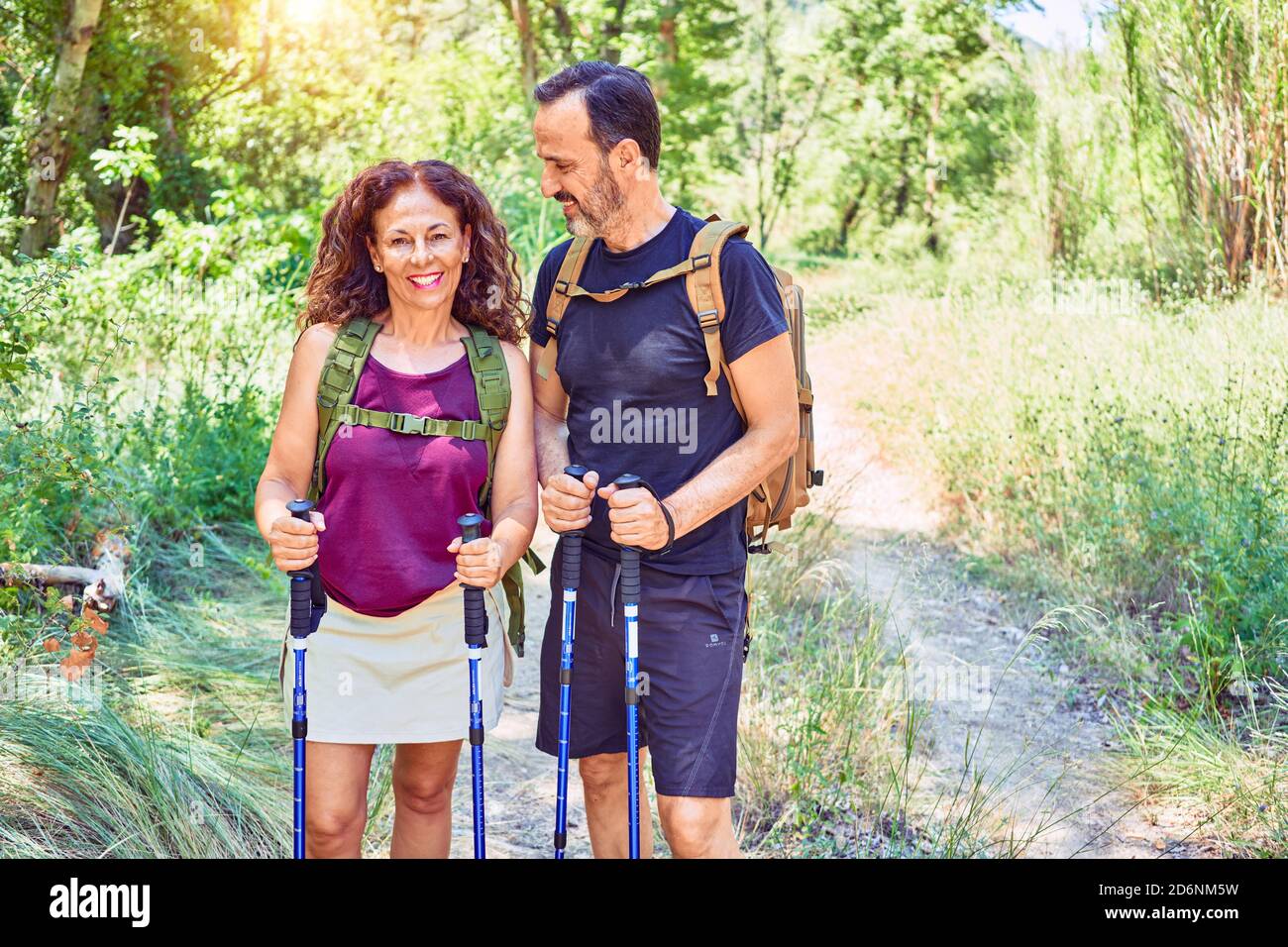 Beautiful couple of hiker wearing backpack smiling happy. Standing with ...