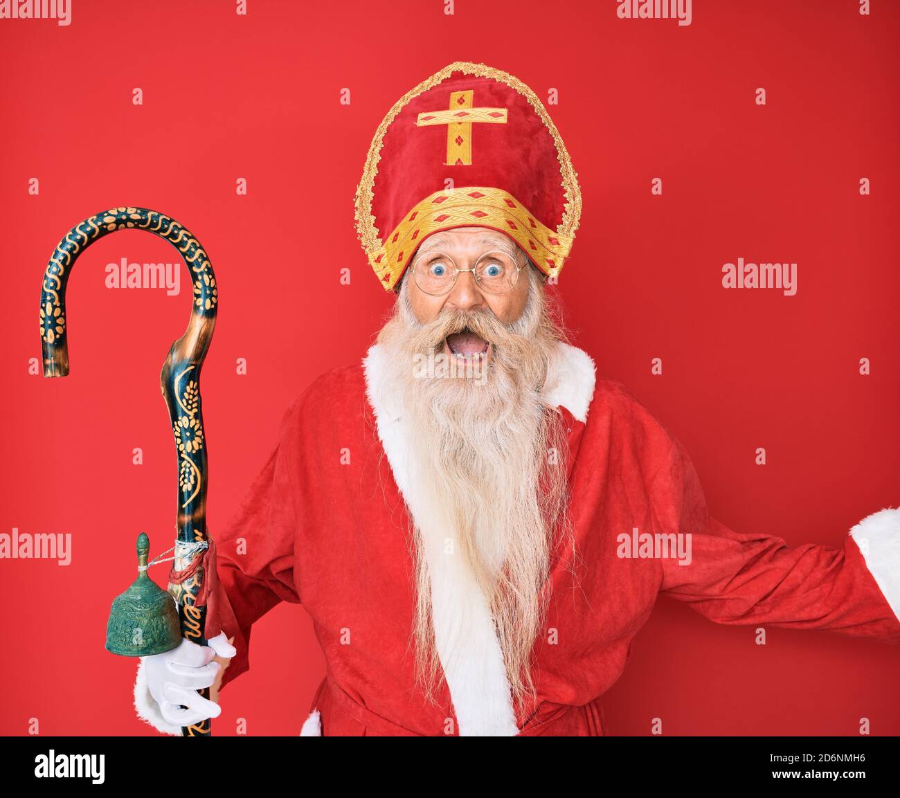 Old senior man with grey hair and long beard wearing traditional saint ...