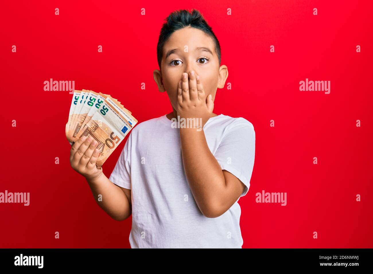 Little boy hispanic kid holding bunch of 50 euro banknotes covering ...