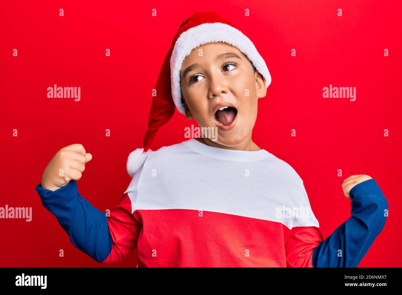 Little boy hispanic kid wearing christmas hat screaming proud ...
