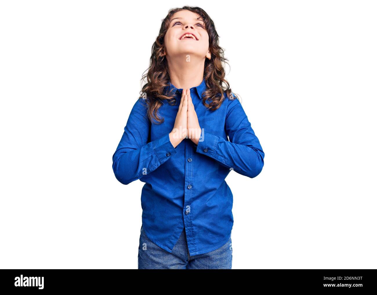 Cute child with long hair wearing casual clothes begging and praying ...