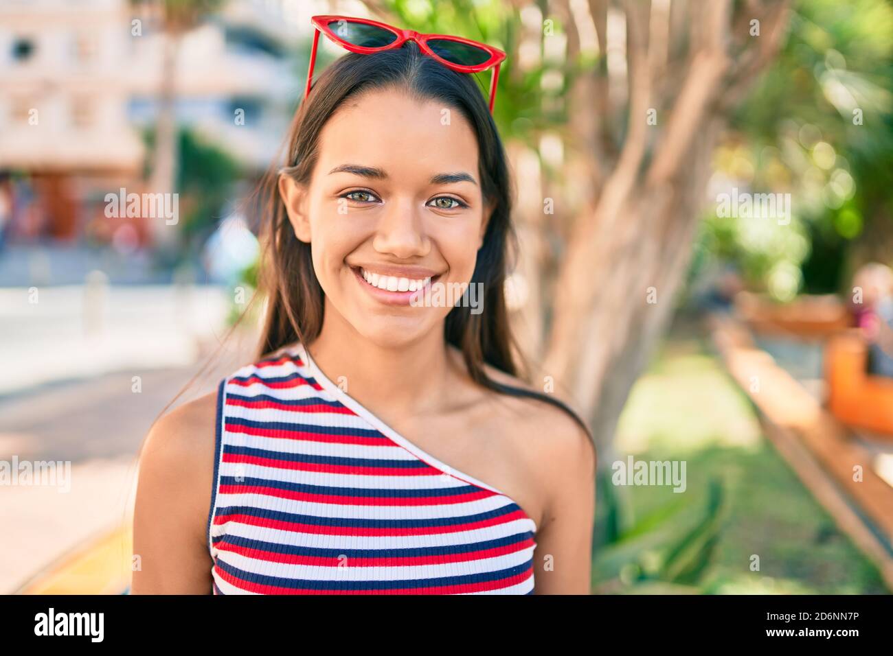 Young latin girl smiling happy walking at the city Stock Photo - Alamy