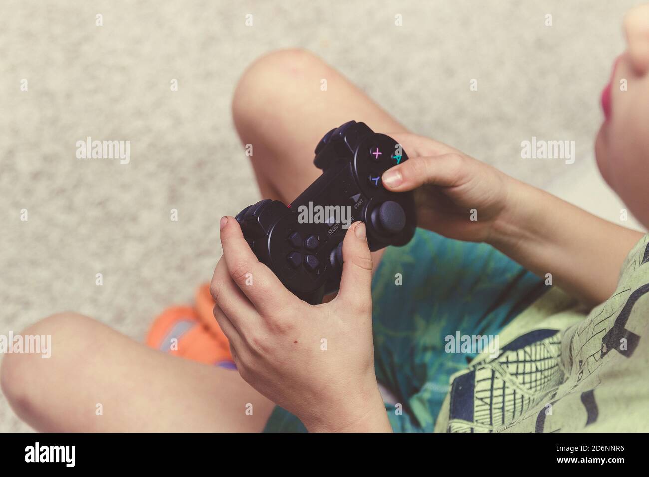 Boy with a gamepad playing on a game console Stock Photo - Alamy