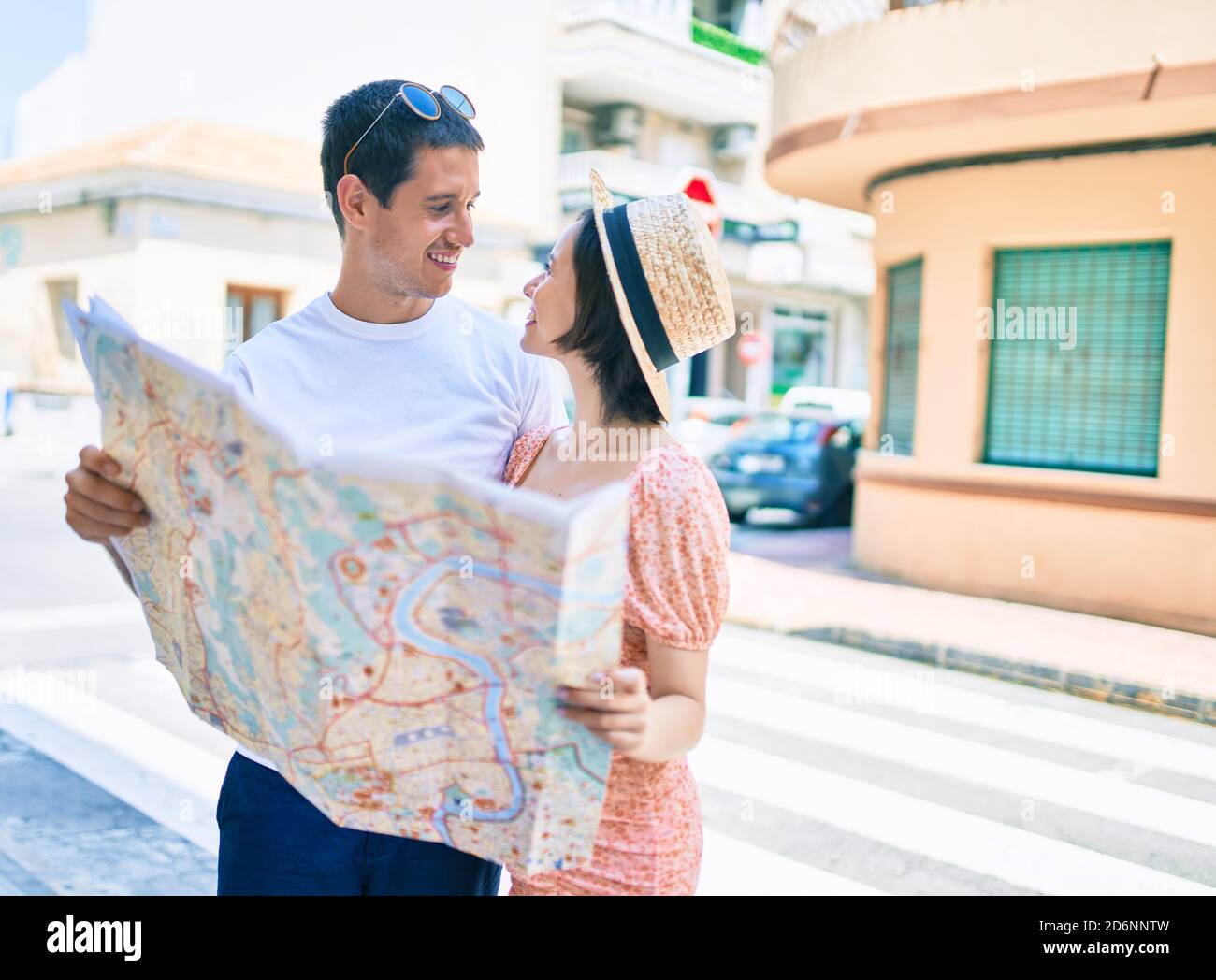 Beautiful couple on vacation smiling happy holding city map at street ...