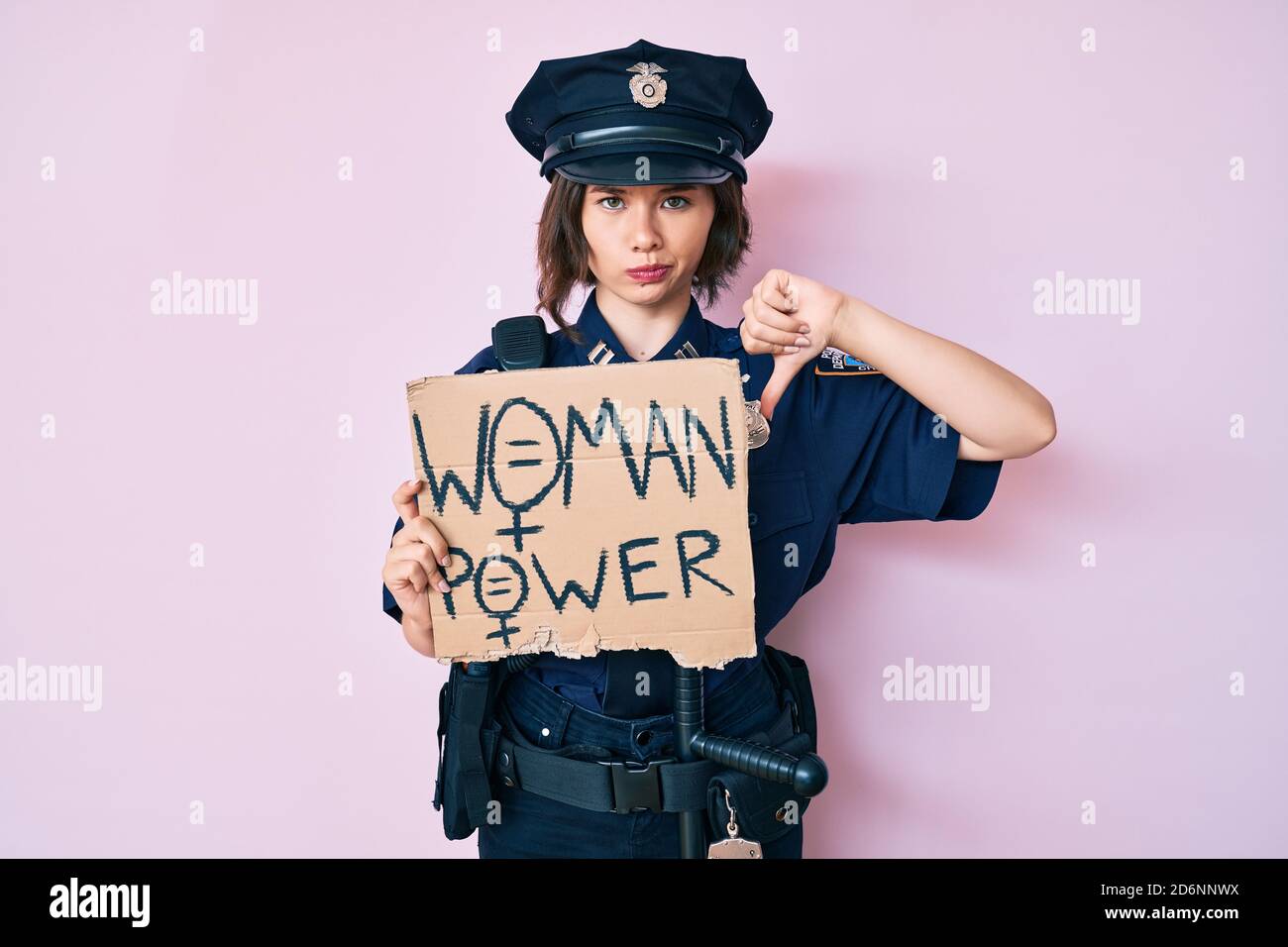 Young beautiful girl wearing police uniform holding woman power banner ...