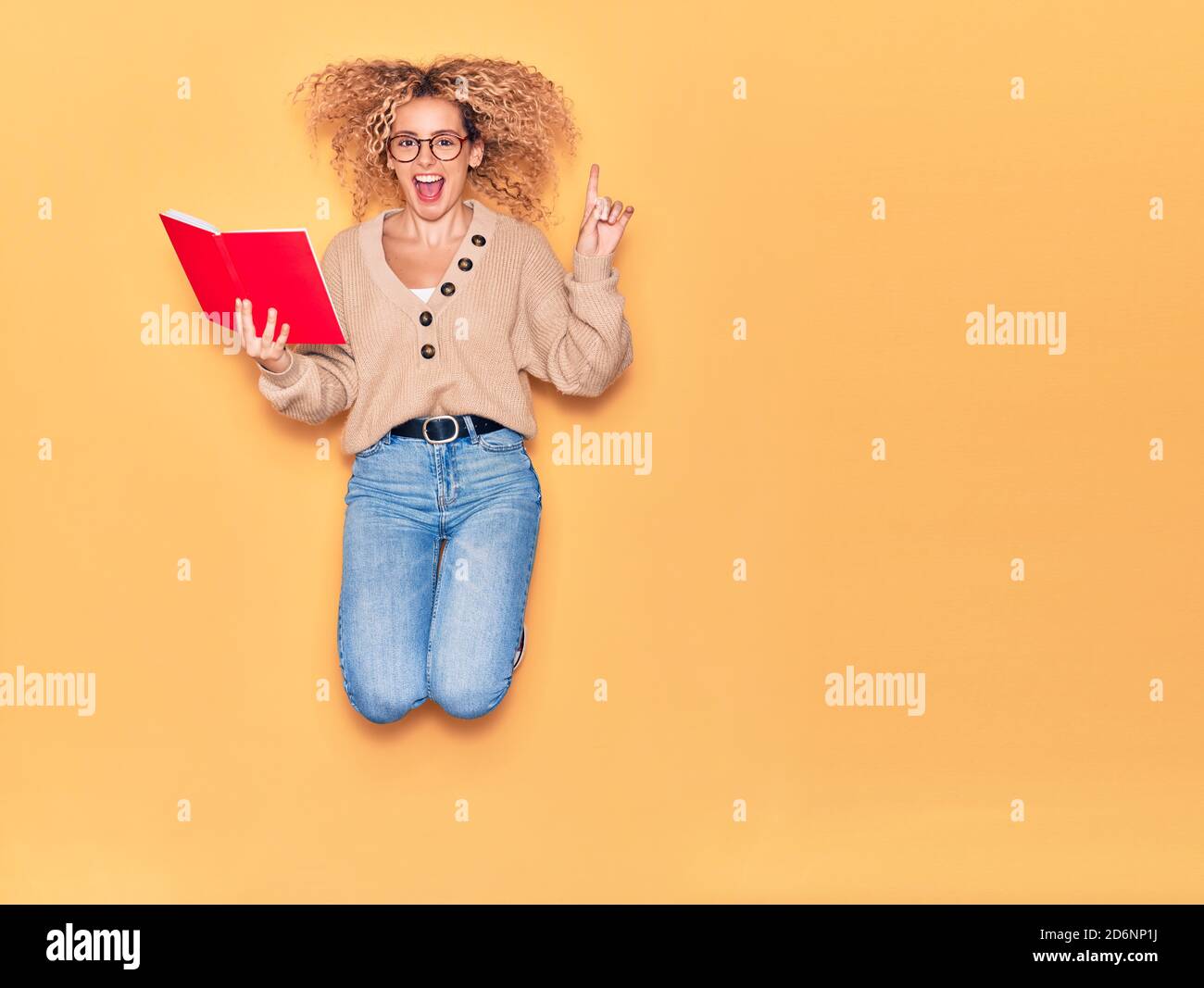 Young beautiful curly student girl wearing glasses smiling happy ...