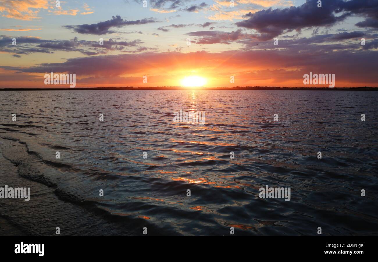 Nice sunset over lake water surface Stock Photo - Alamy