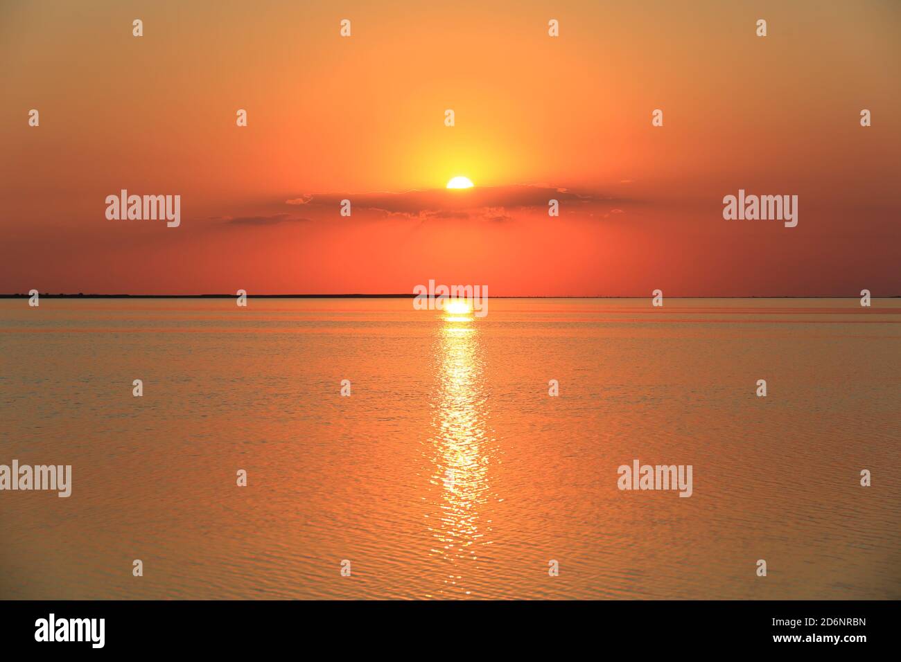 sunset scene with red sun over sea waterf surface Stock Photo - Alamy
