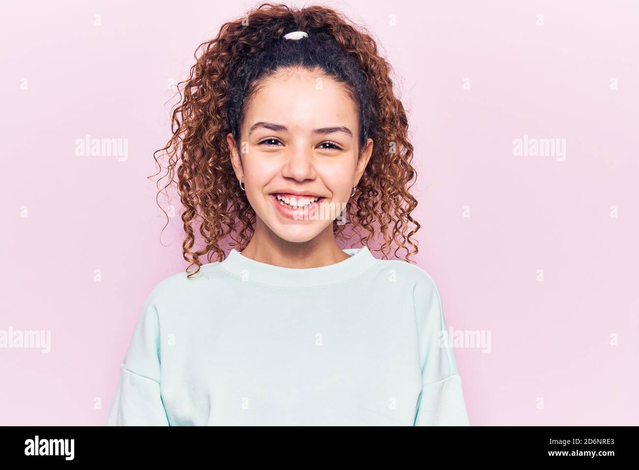 Beautiful kid girl with curly hair wearing casual clothes looking ...