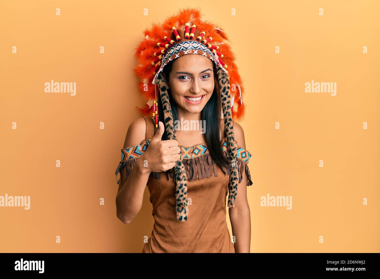 Young brunette woman wearing indian costume doing happy thumbs up ...