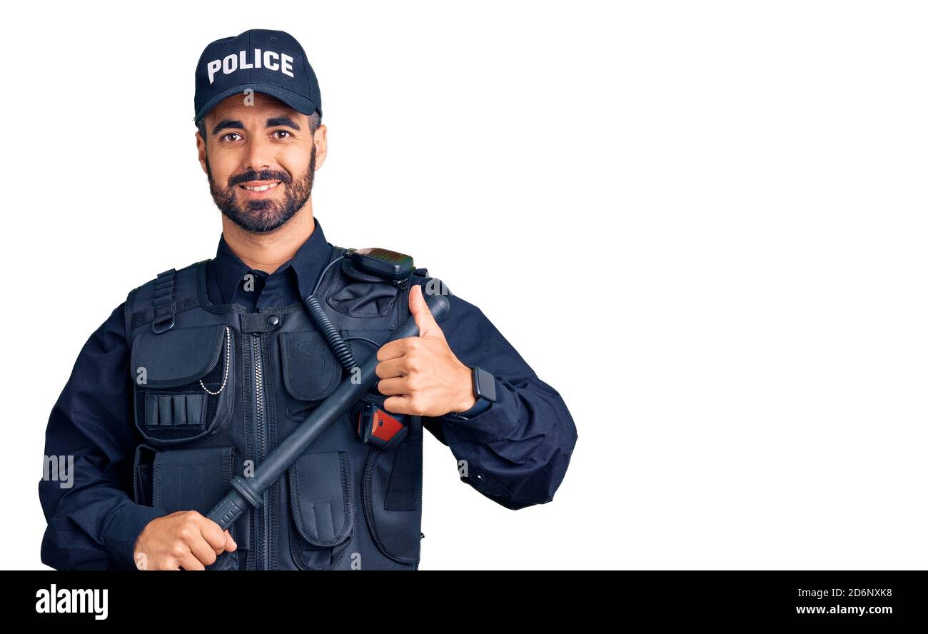Young hispanic man wearing police uniform holding baton smiling happy ...