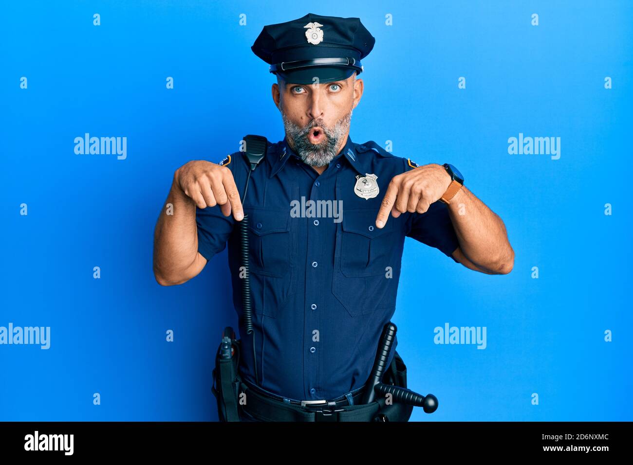 Middle age handsome man wearing police uniform pointing down with ...