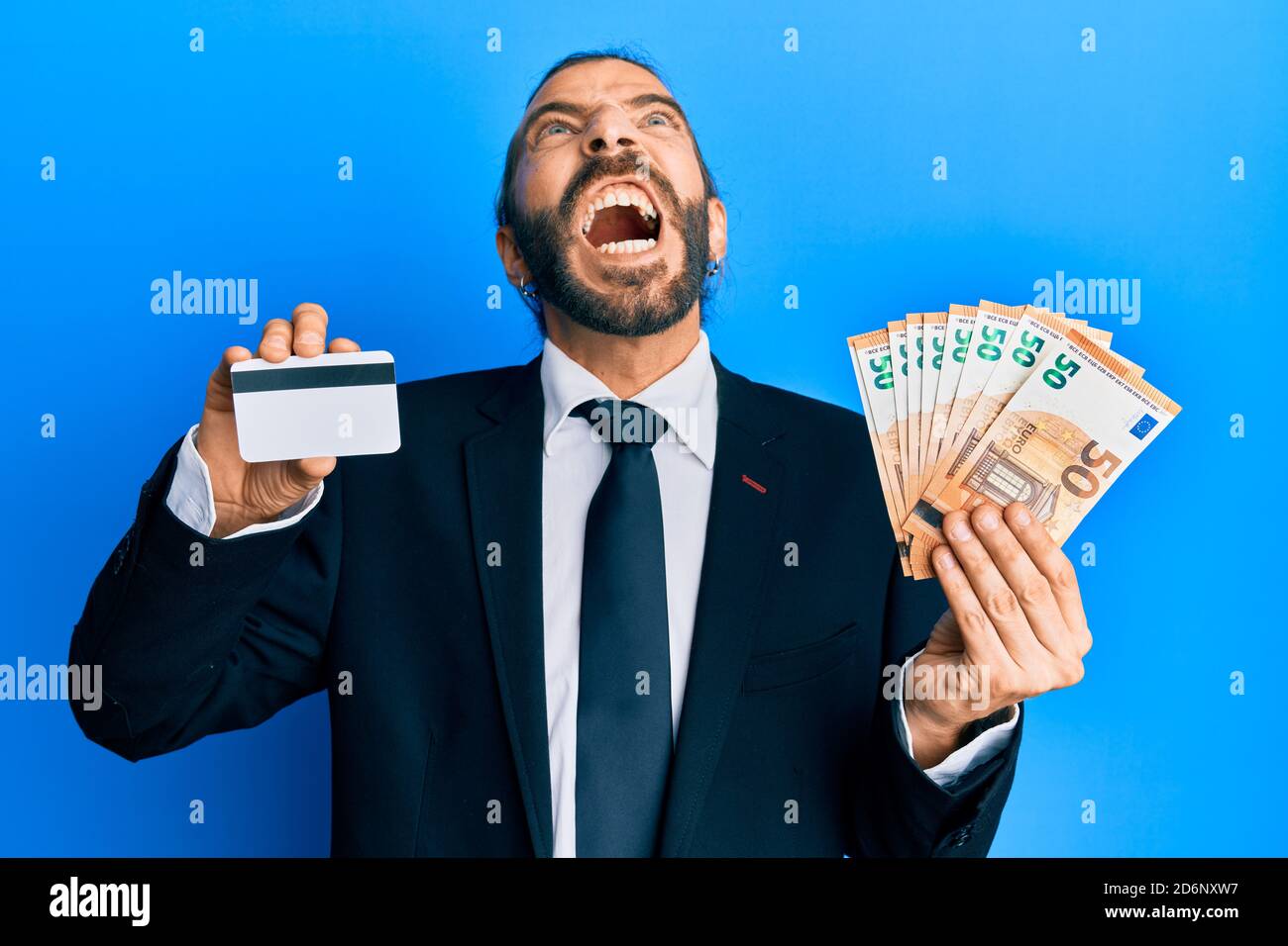 Attractive business man with long hair and beard holding credit card ...