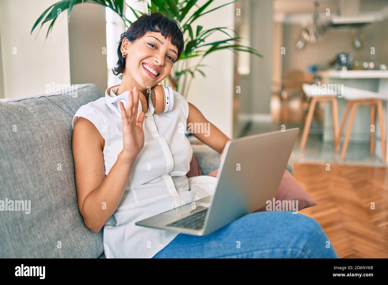 Beautiful brunette woman with short hair at home doing video conference ...