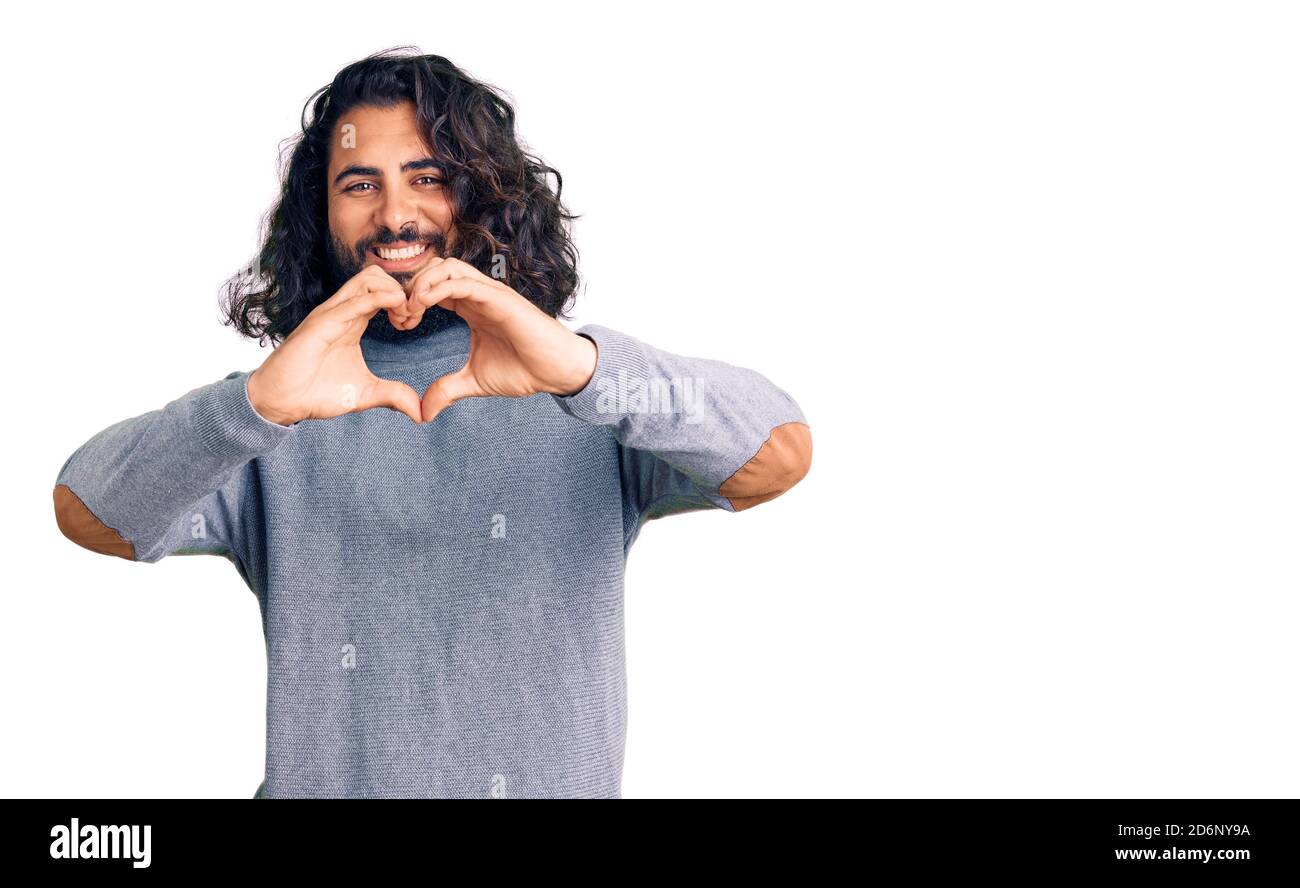 Young arab man wearing casual clothes smiling in love doing heart ...