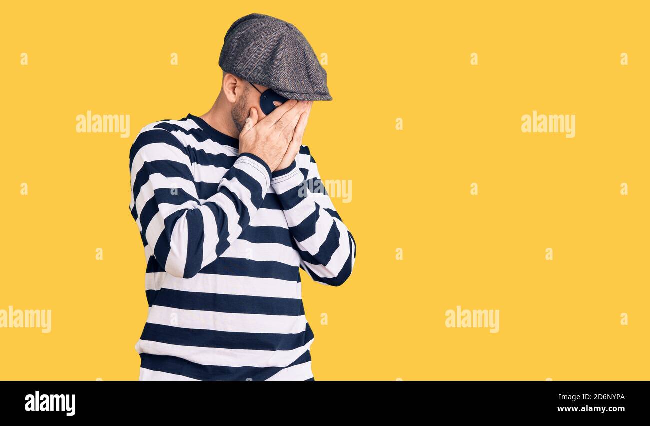 Young handsome man wearing burglar mask with sad expression covering ...