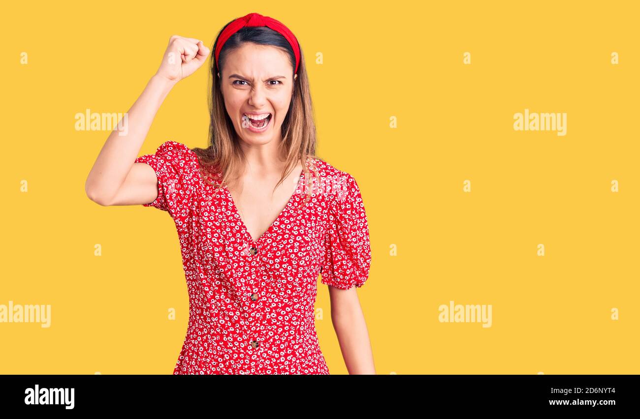 Young beautiful girl wearing dress and diadem angry and mad raising ...
