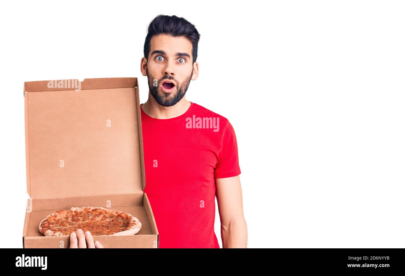 Young handsome man with beard holding delivery cardboard with italian ...
