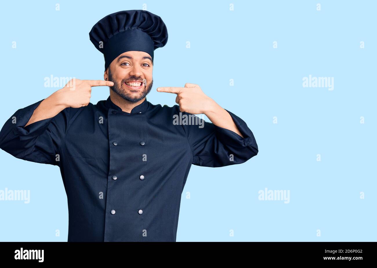 Young hispanic man wearing cooker uniform smiling cheerful showing and ...