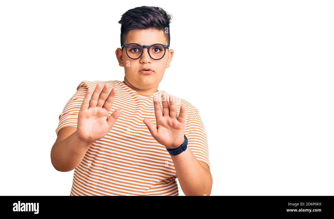 Little boy kid wearing casual clothes and glasses moving away hands ...