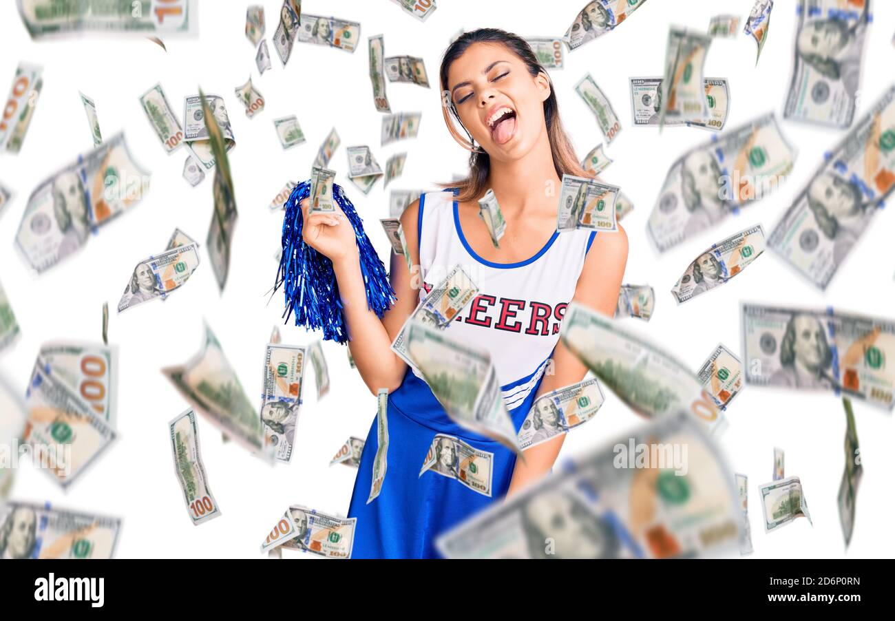 Young beautiful woman wearing cheerleader uniform sticking tongue out ...