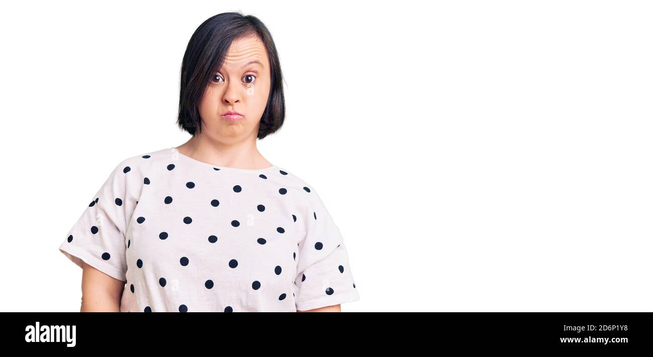 Brunette woman with down syndrome wearing casual clothes depressed and ...