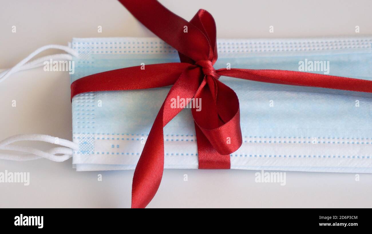 Surgical face mask with red ribbon as a present on white background ...