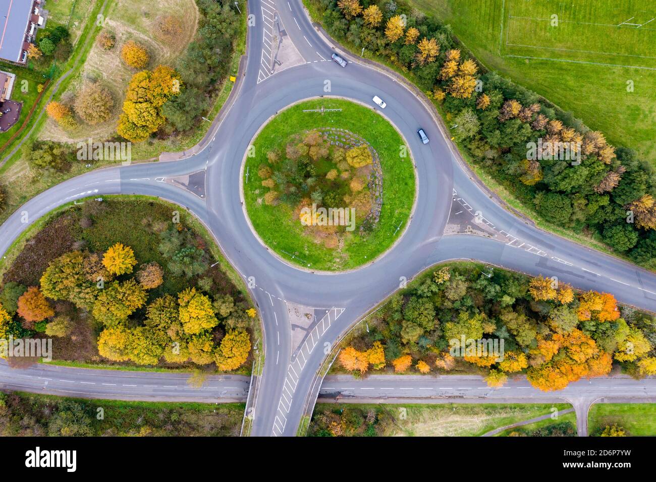 Aerial view of a traffic roundabout surrounded by trees in their autumn ...