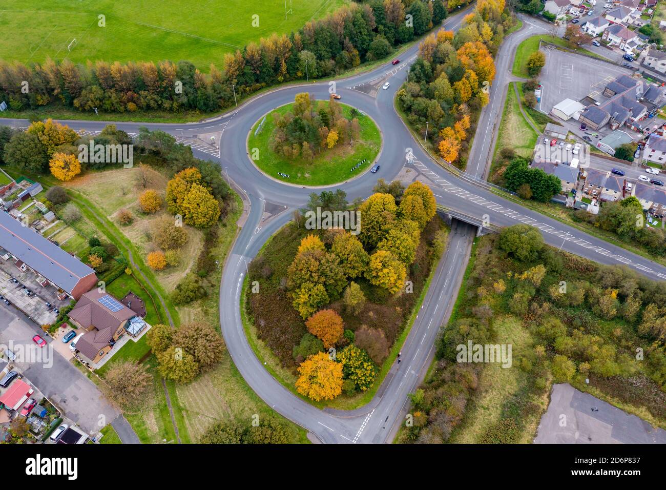 Aerial view of a traffic roundabout surrounded by trees in their autumn ...
