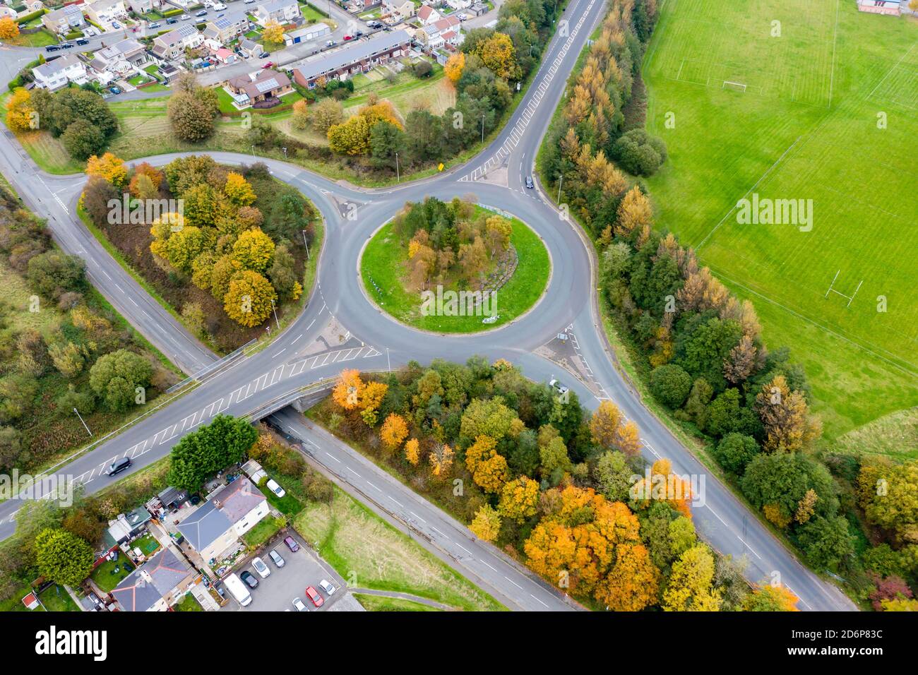 Aerial view of a traffic roundabout surrounded by trees in their autumn ...