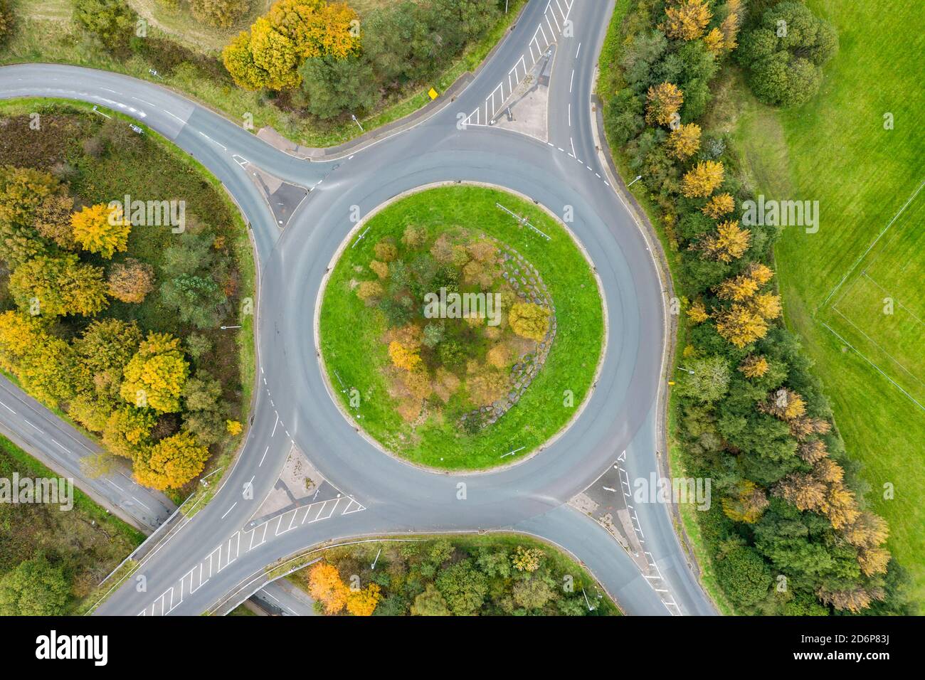 Aerial view of a traffic roundabout surrounded by trees in their autumn ...