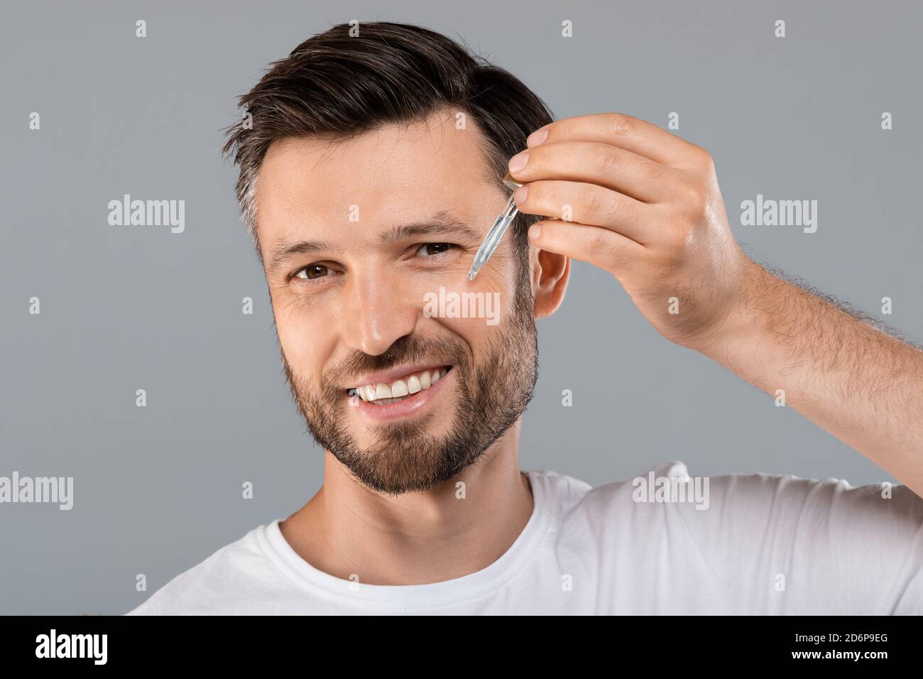 Middle-aged handsome man applying anti-aging face serum Stock Photo - Alamy