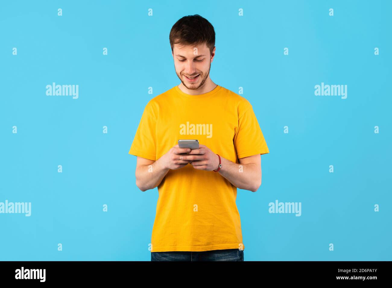 Happy guy using mobile phone at studio Stock Photo - Alamy