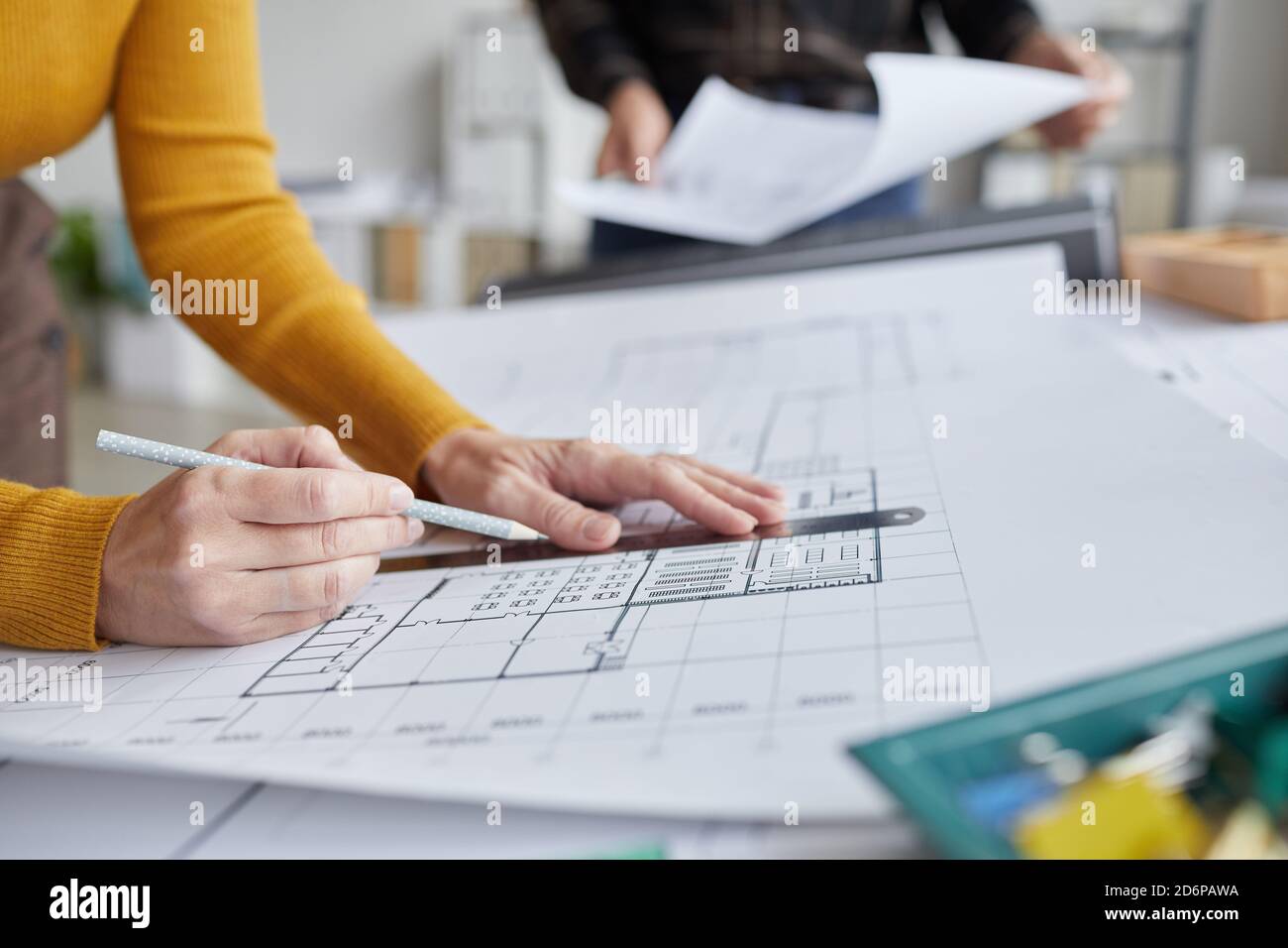 Close up of unrecognizable female architect drawing blueprints while ...