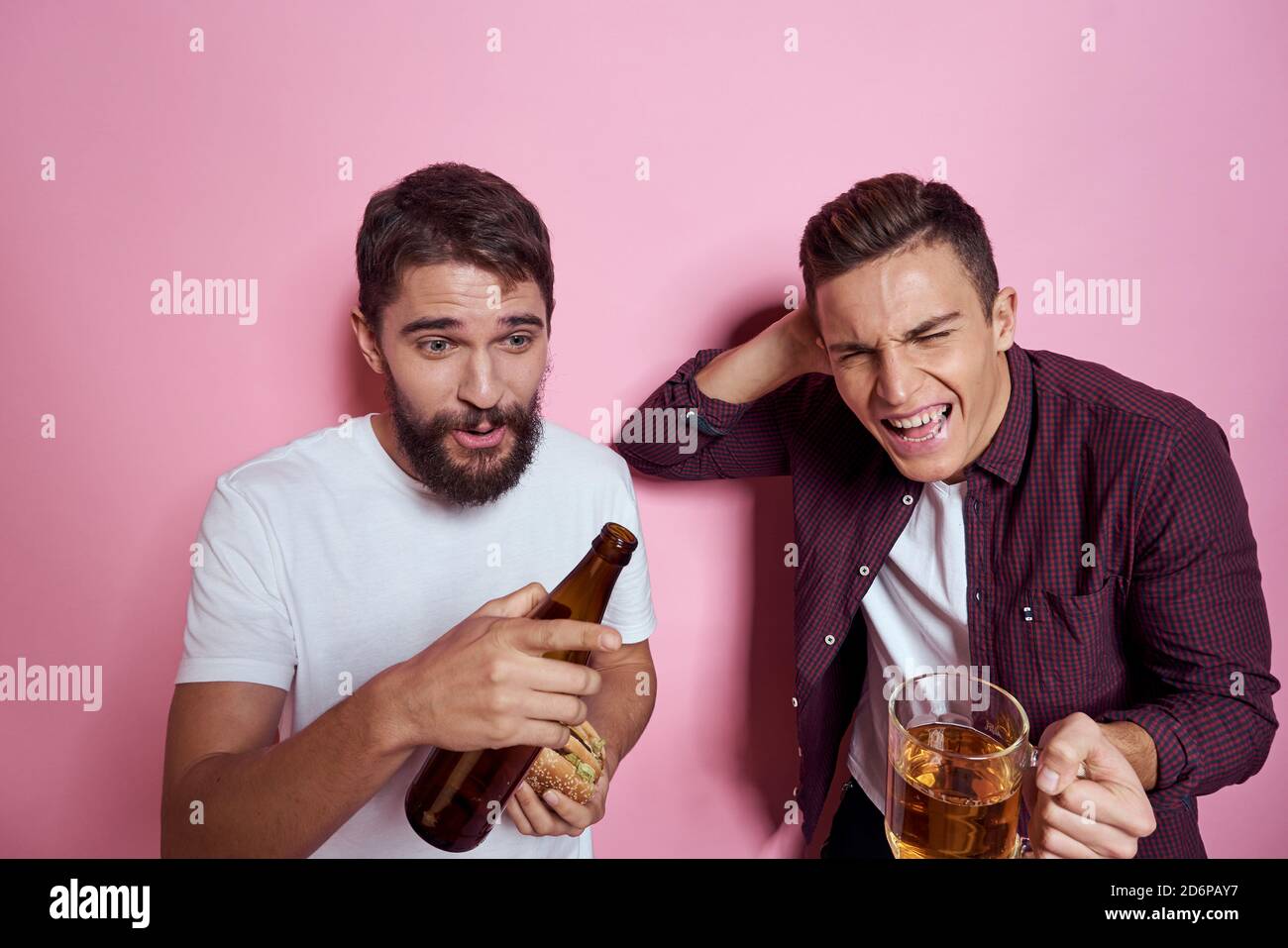 Two men drink beer friendship drunk alcohol lifestyle pink background ...