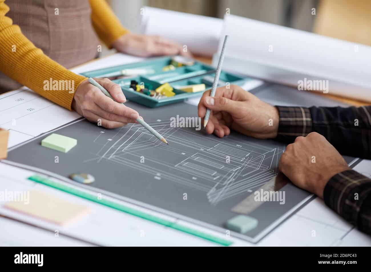 Close up of two unrecognizable architects pointing at floor plan while ...