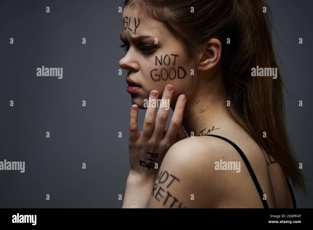 Emotional woman with inscriptions on body upset with frustration gray ...