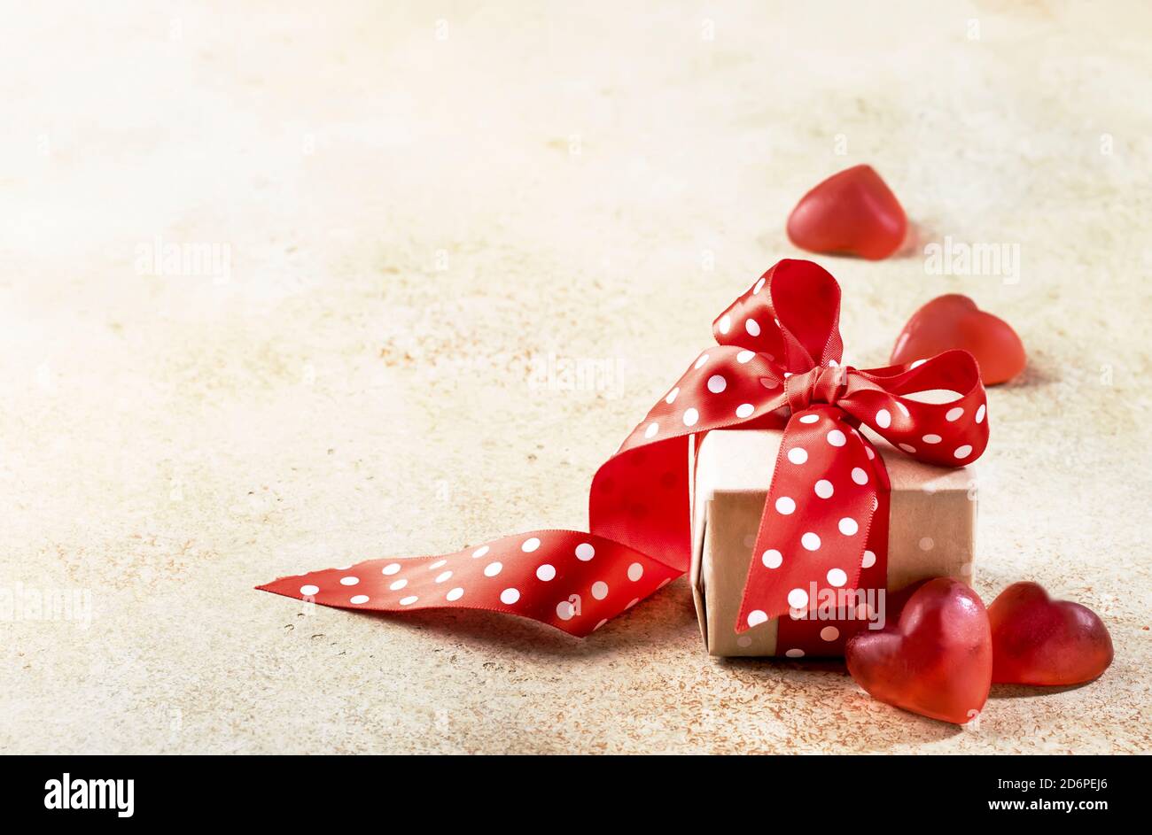 Valentine's day background. Gift in kraft box with red bow on red ...