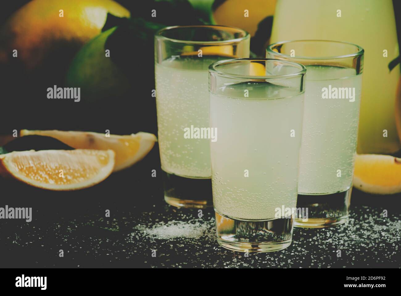 Homemade lemonade with lemon, lime, sugar and soda on a dark background ...