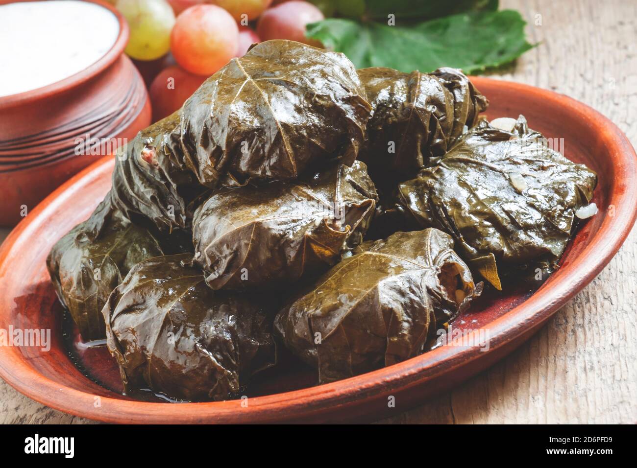 Traditional Greek dolma with meat in grape leaves, yogurt sauce, grapes ...