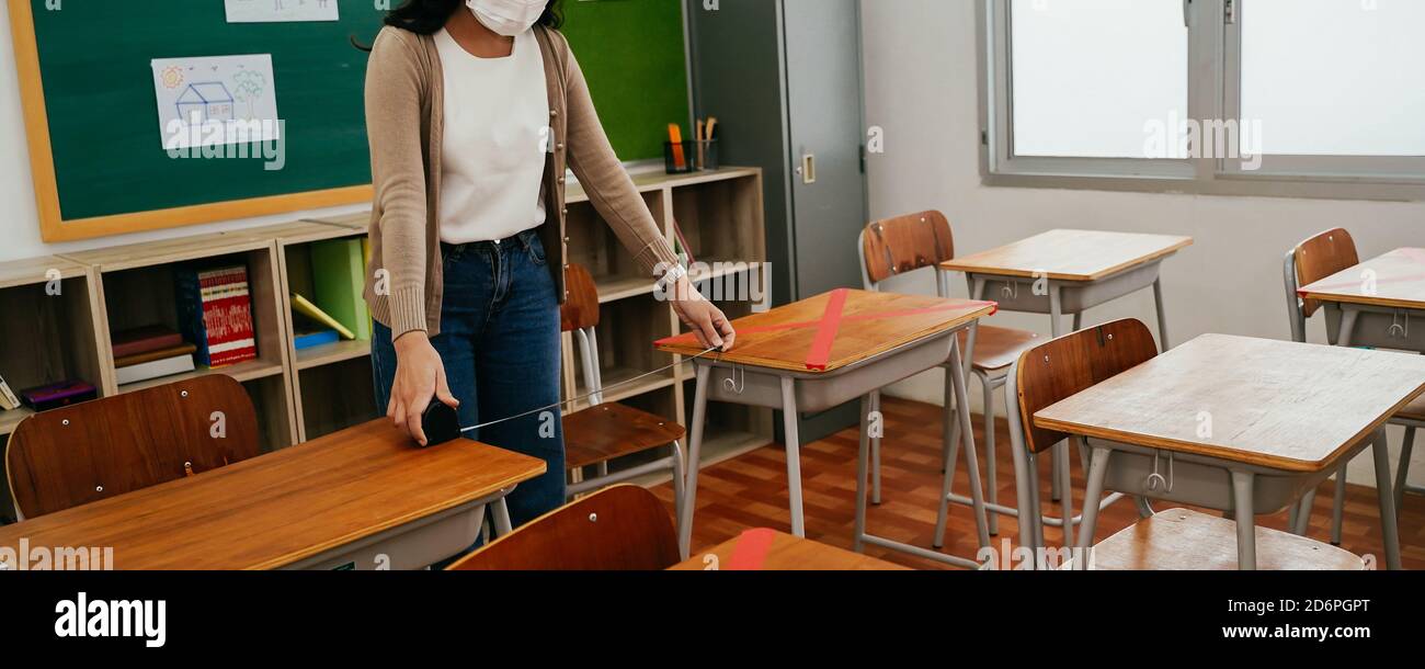 Banner of female teacher wearing a face mask measures distances between ...