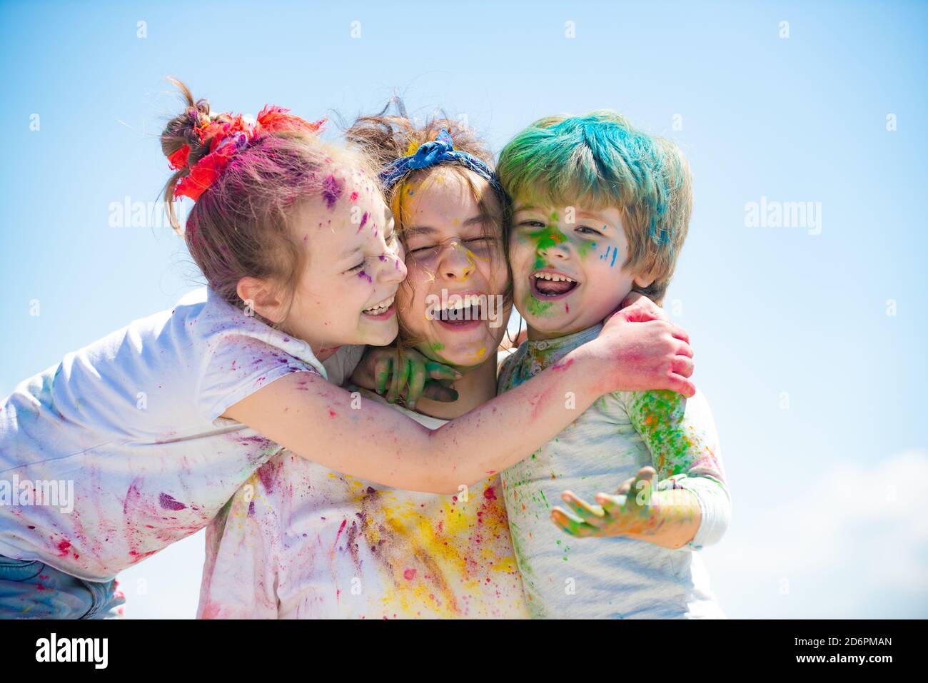 Screaming portrait of kids with face smeared with colored powder ...