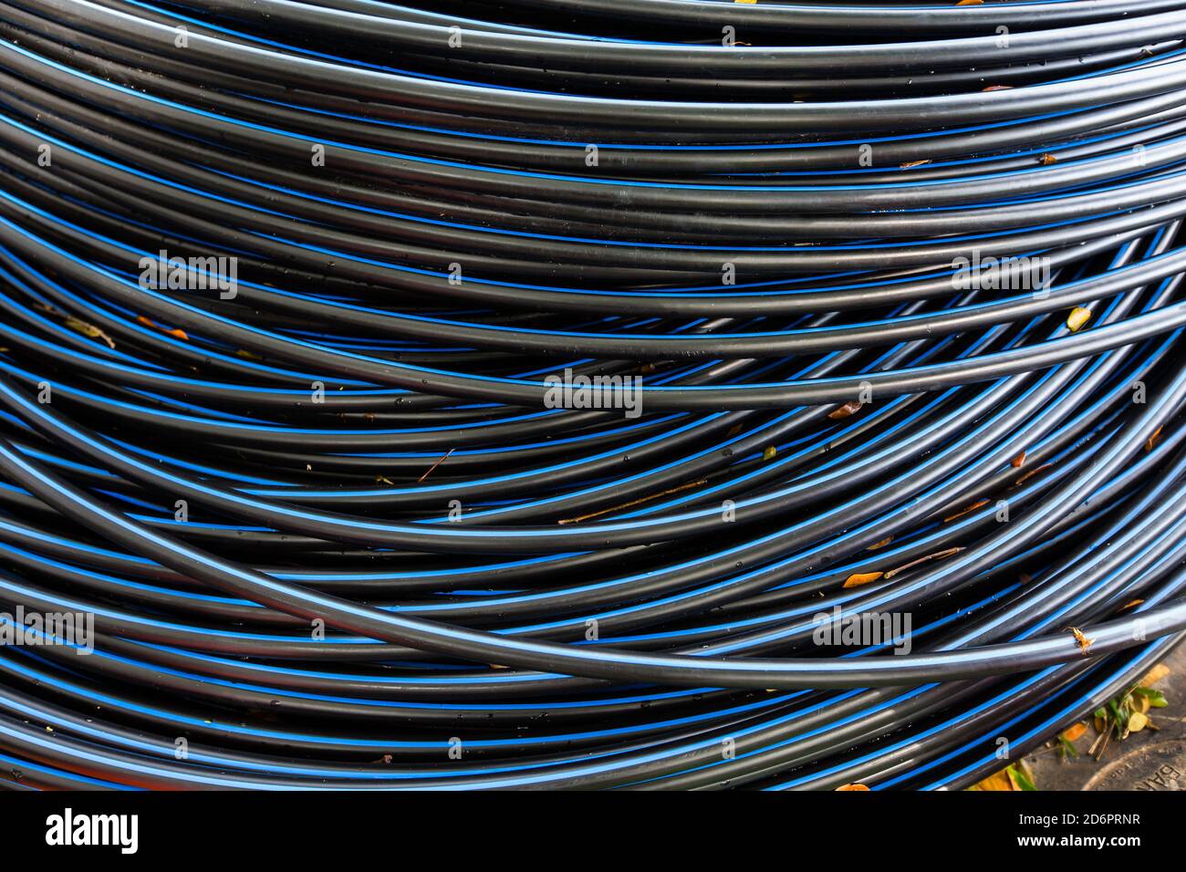 Close up of fiber optics black colour cable in coil up position, it is ...