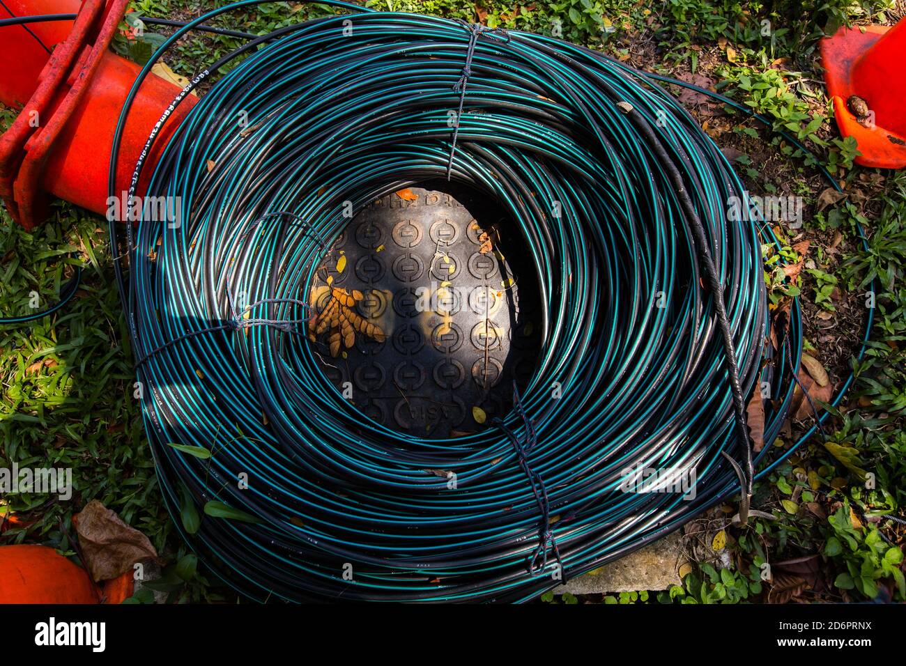 Top down view of a big coil of fiber optics dark colour cables coiled ...