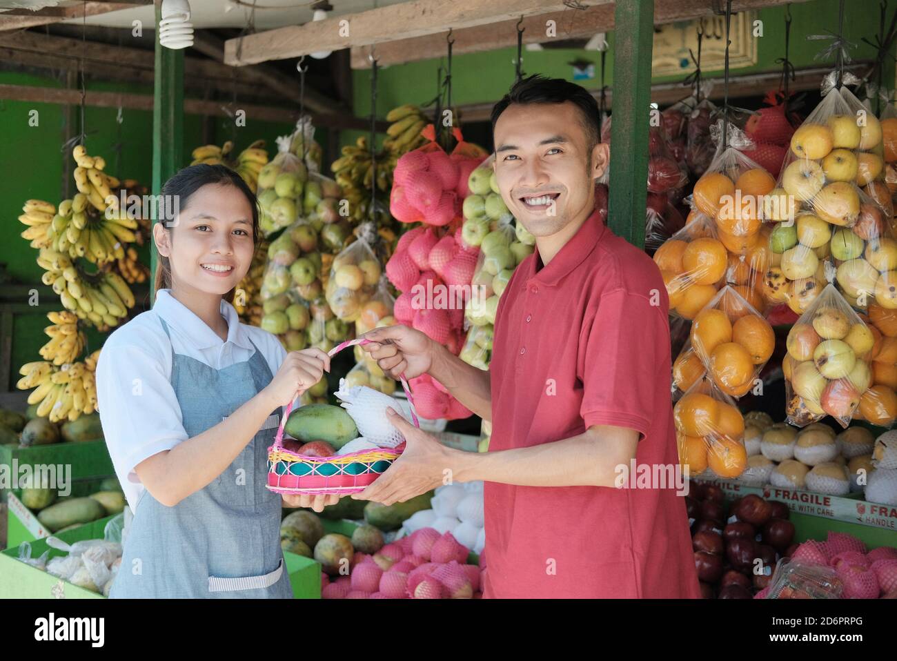 Female assistant helping customer at fruit counter of fruit market ...