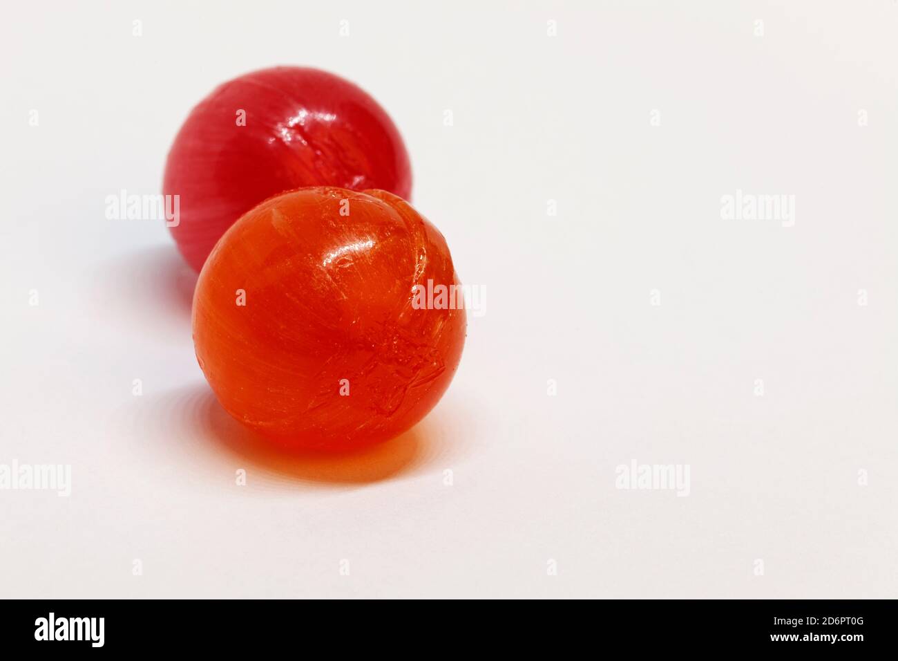 hard red and orange candies on white background Stock Photo - Alamy
