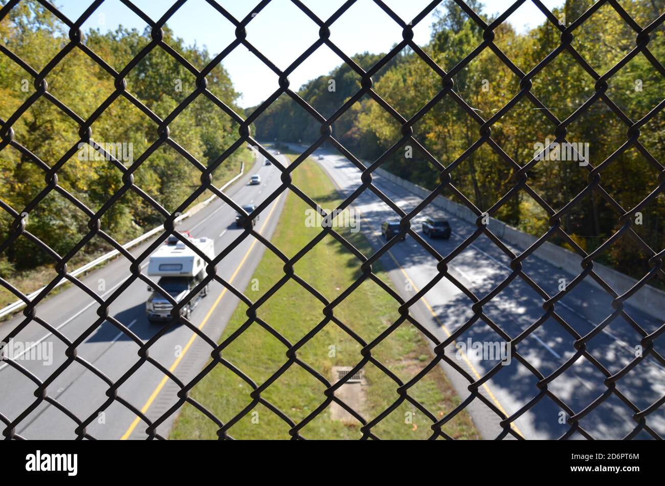 metal chain link fence over highway or road with cars Stock Photo - Alamy